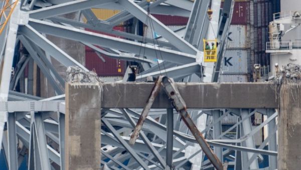 Workers remove first piece of Key Bridge from ship as salvage operation ...
